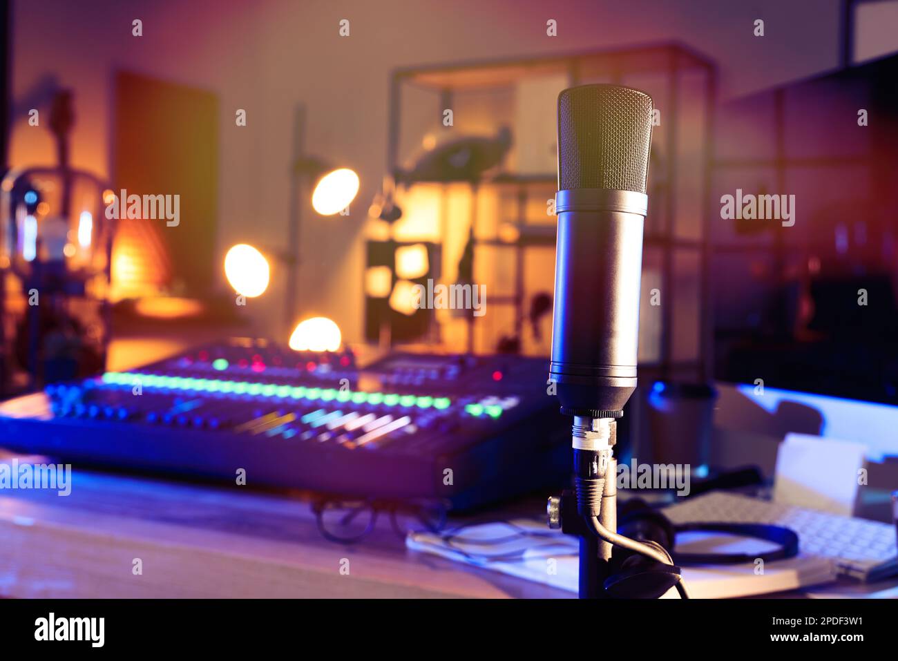 Microphone near table with professional mixing console in radio studio ...