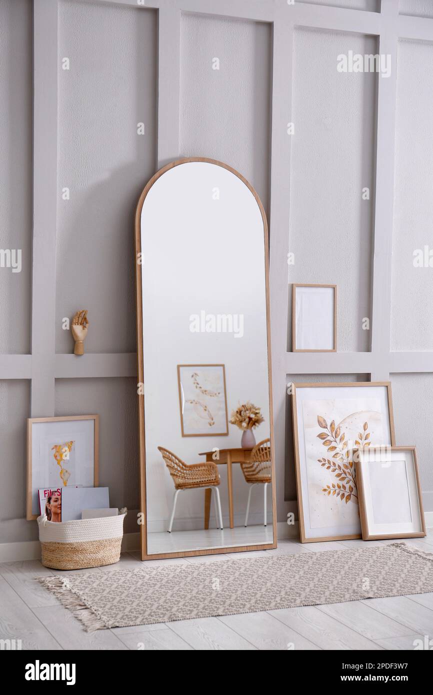 Light room interior with large mirror, beautiful pictures and pouf near ...