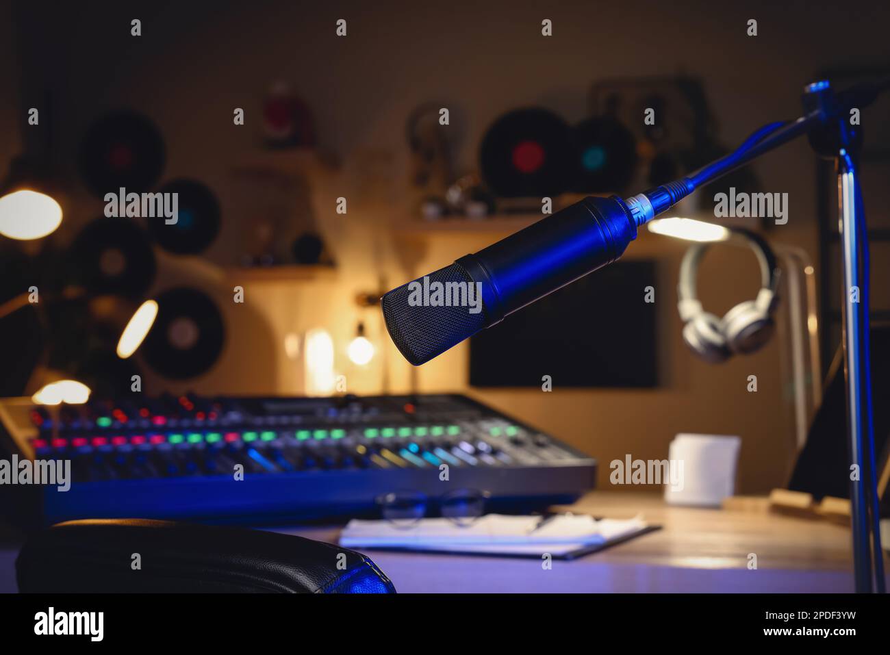 Microphone near table with professional mixing console in radio studio ...