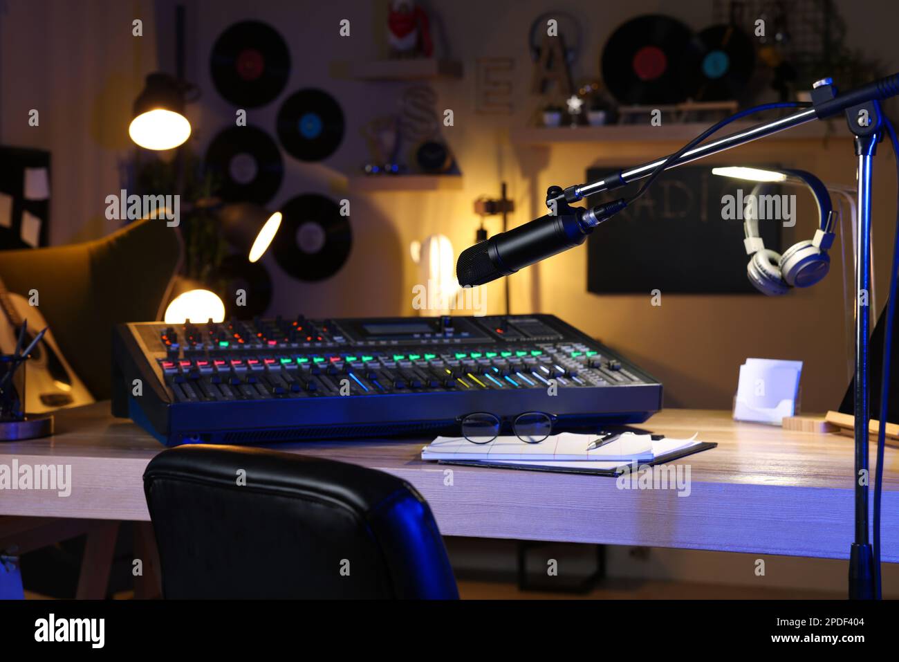 Microphone near table with professional mixing console in radio studio ...