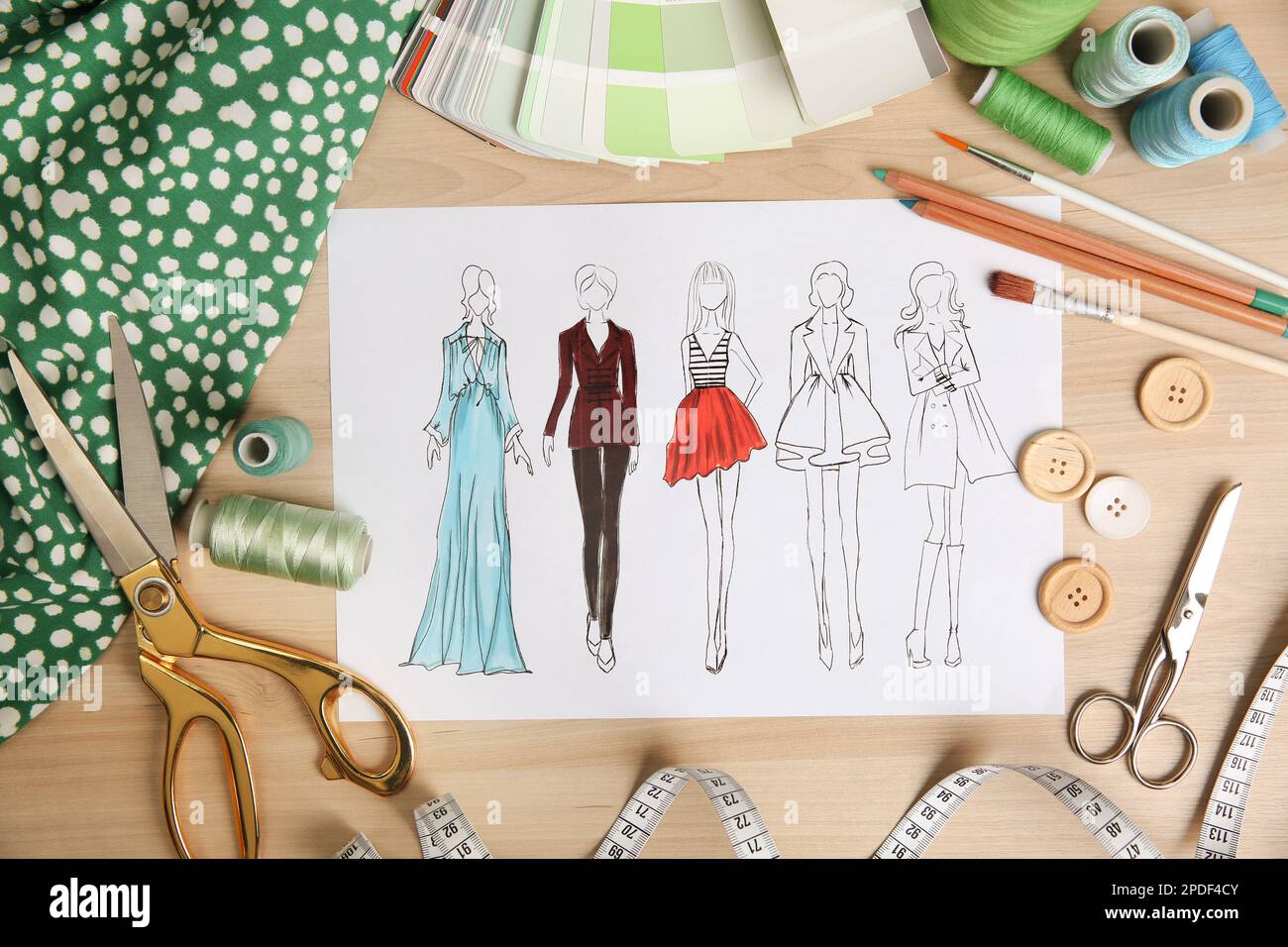 Sketch of fashion clothes and thread supplies at designer's workplace ...