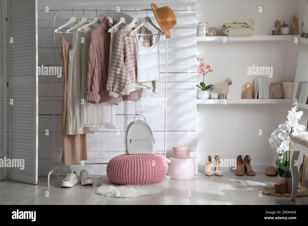 Rack with different stylish clothes, shoes and decorative elements in ...