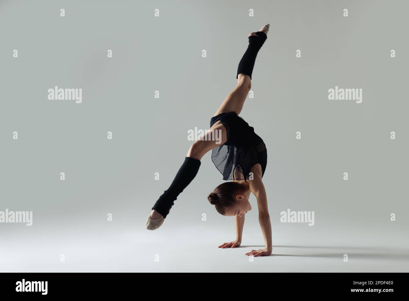 Cute little gymnast doing handstand on white background Stock Photo - Alamy