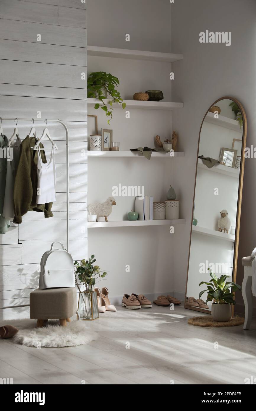 Rack with different stylish clothes, shoes and decorative elements in ...