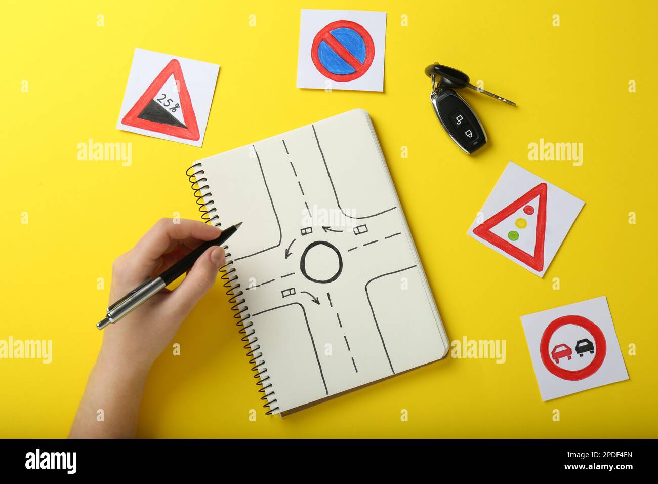 Woman with workbook for driving lessons and road signs on yellow ...