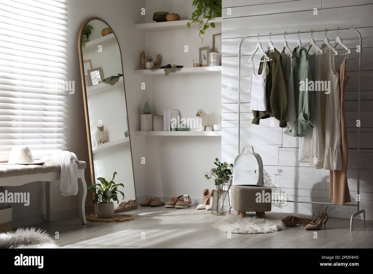 Rack with different stylish clothes, shoes and decorative elements in ...