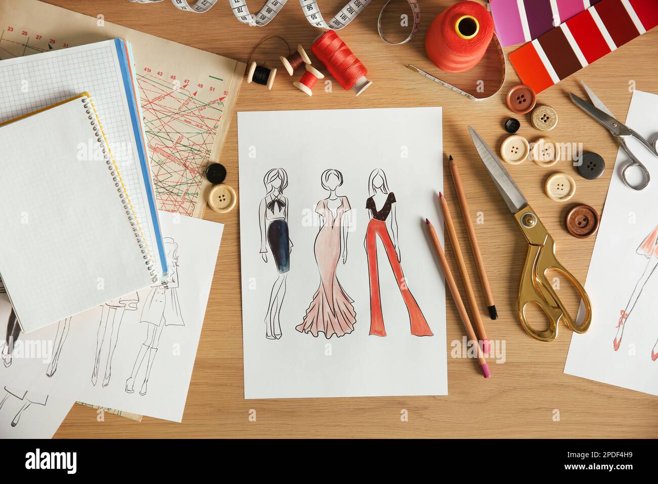 Sketches of fashion clothes and thread supplies at designer's workplace ...