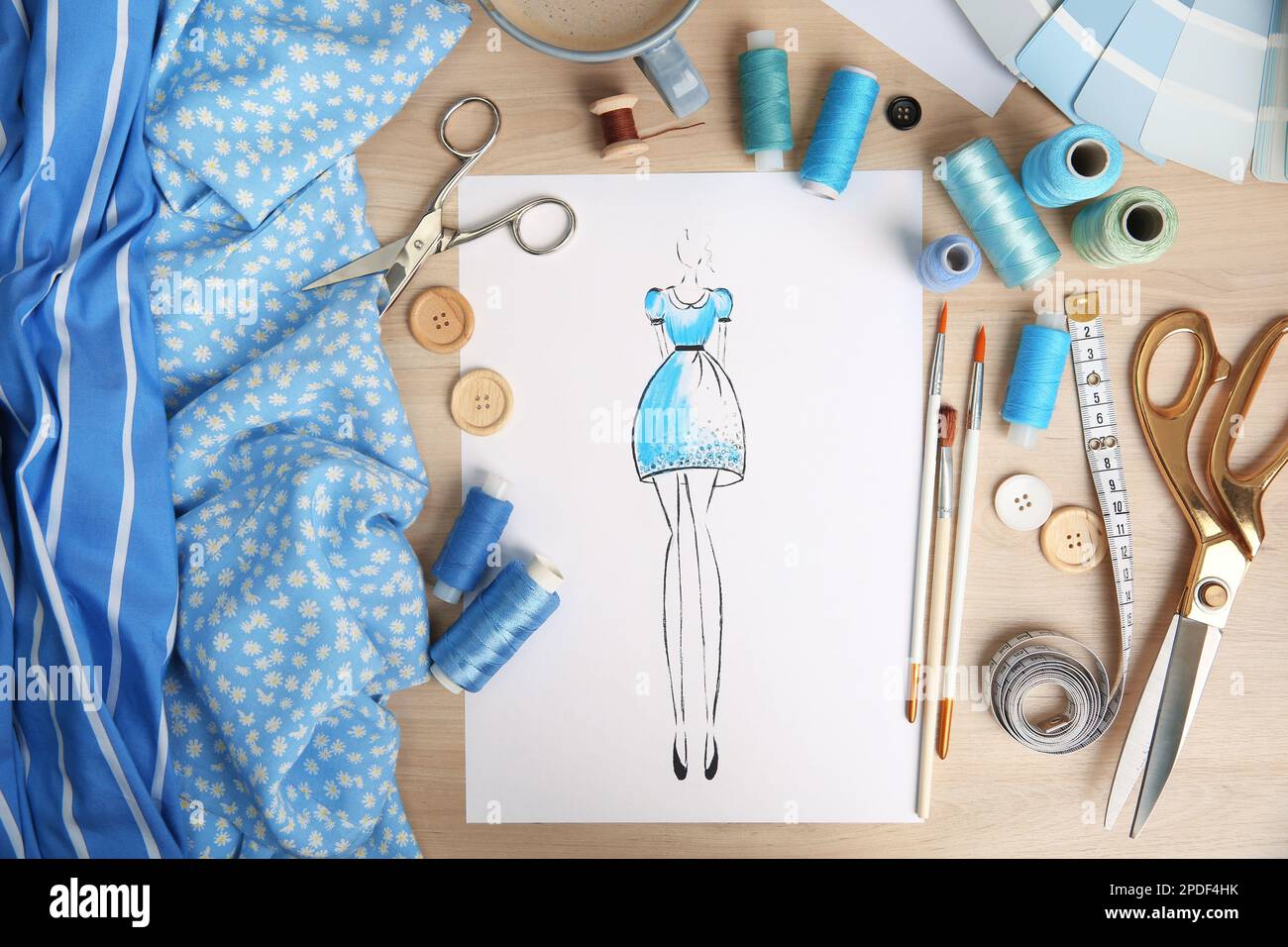 Sketch of fashion dress and thread supplies at designer's workplace ...