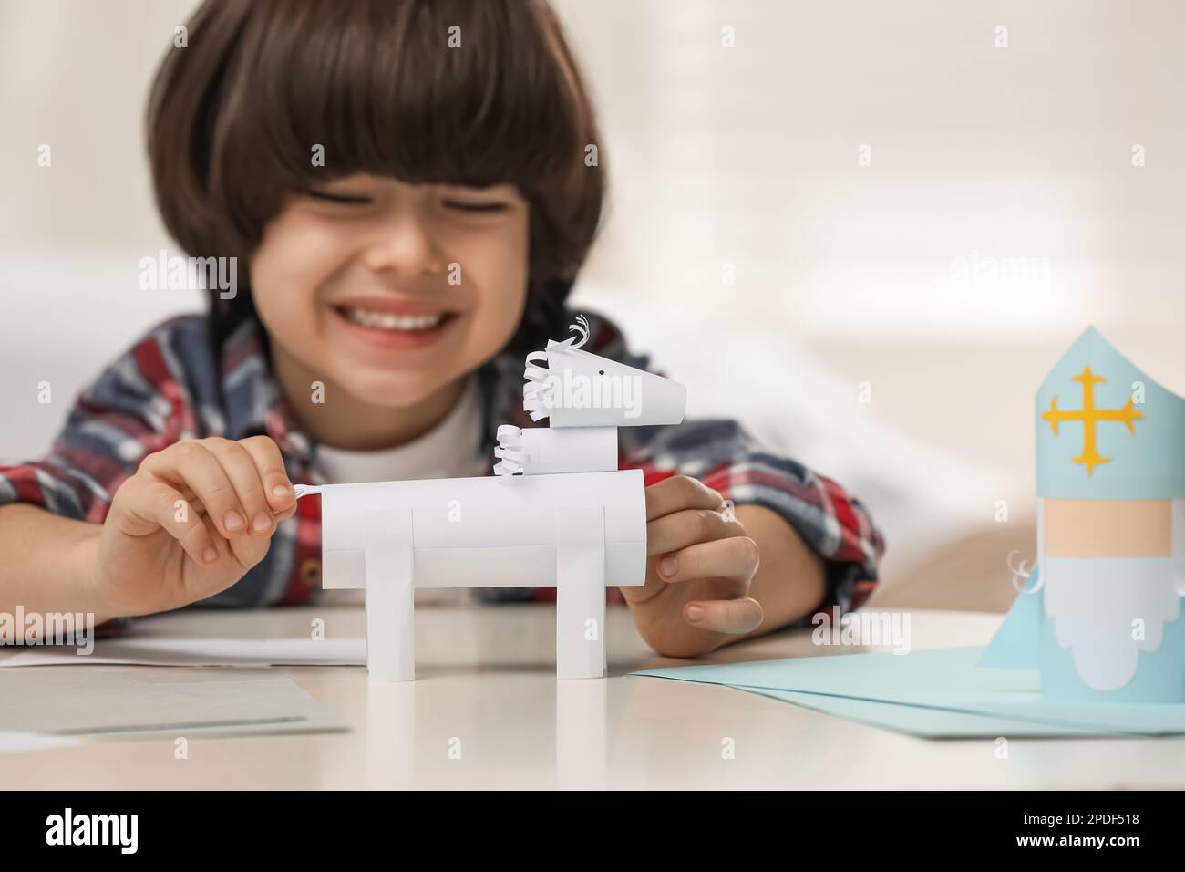 Cute little boy with paper toy for Saint Nicholas day at home, focus on ...