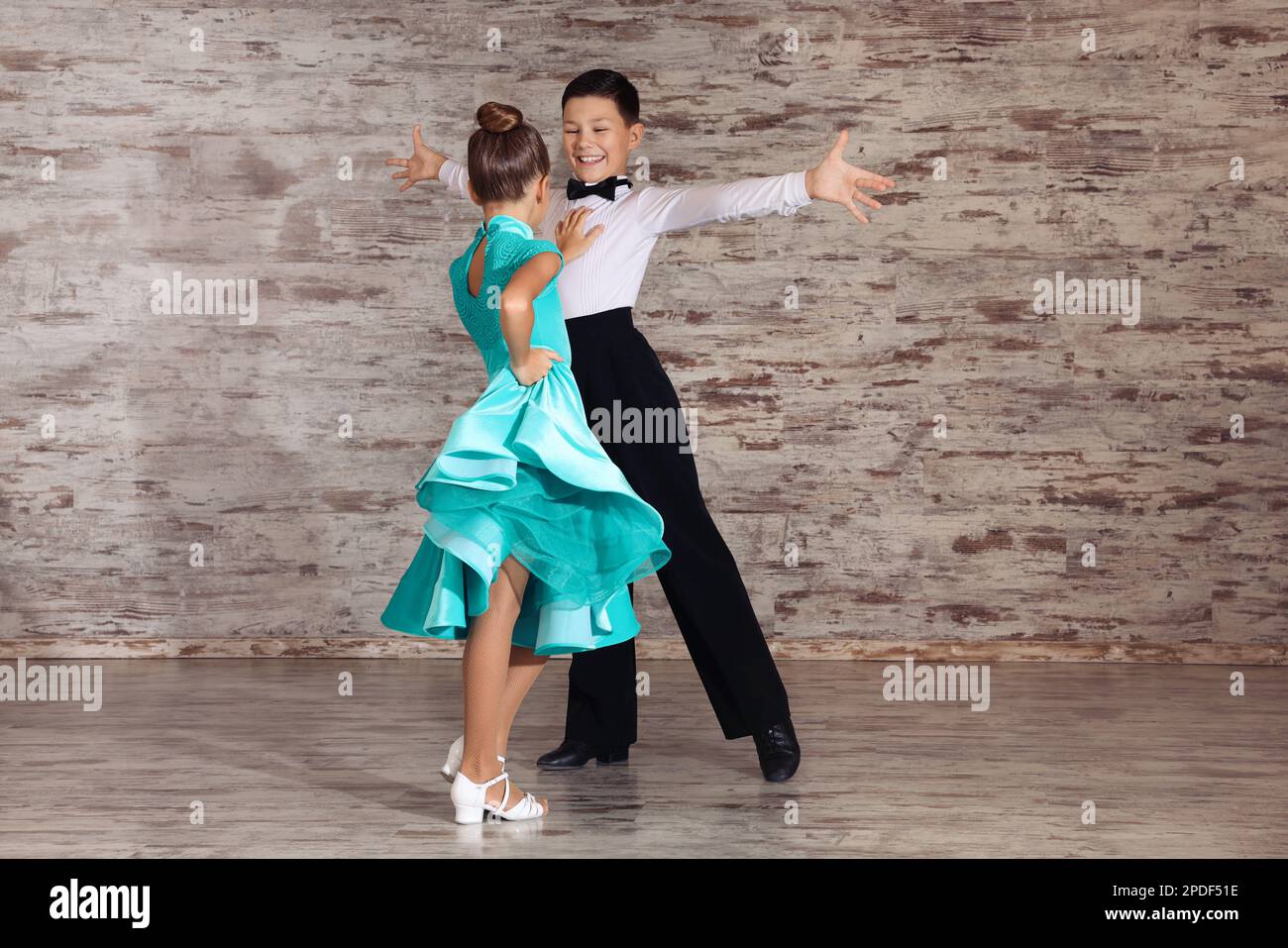 Beautifully dressed couple of kids dancing together in studio Stock ...