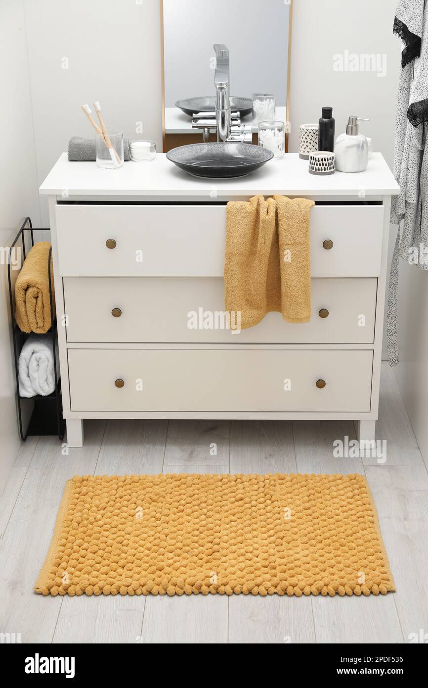 Mat near base cabinet with sink in bathroom Stock Photo - Alamy