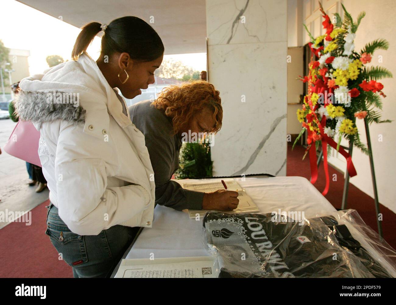 Mourner Edna Rogers, right, signs a condolence book as Tanea Anderson ...