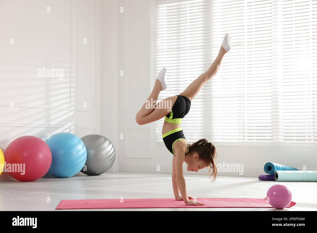 Cute little girl doing handstand indoors. Gymnastics Stock Photo - Alamy