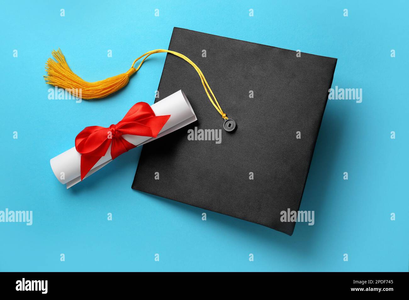 Graduation hat and diploma on light blue background, flat lay Stock ...
