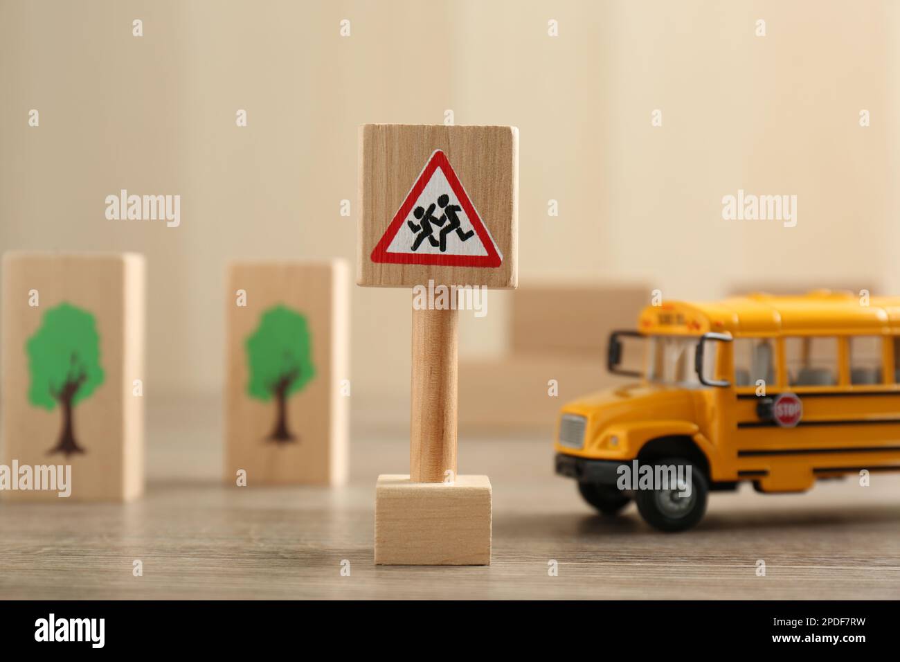 Traffic sign Attention children crossing street and toy bus on wooden ...