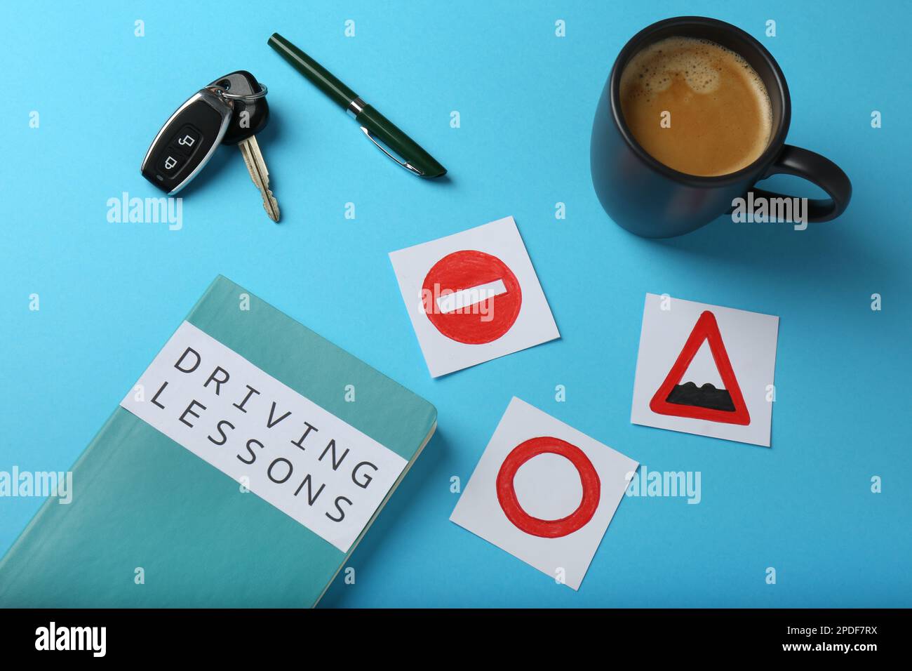 Composition with workbook for driving lessons on light blue background ...