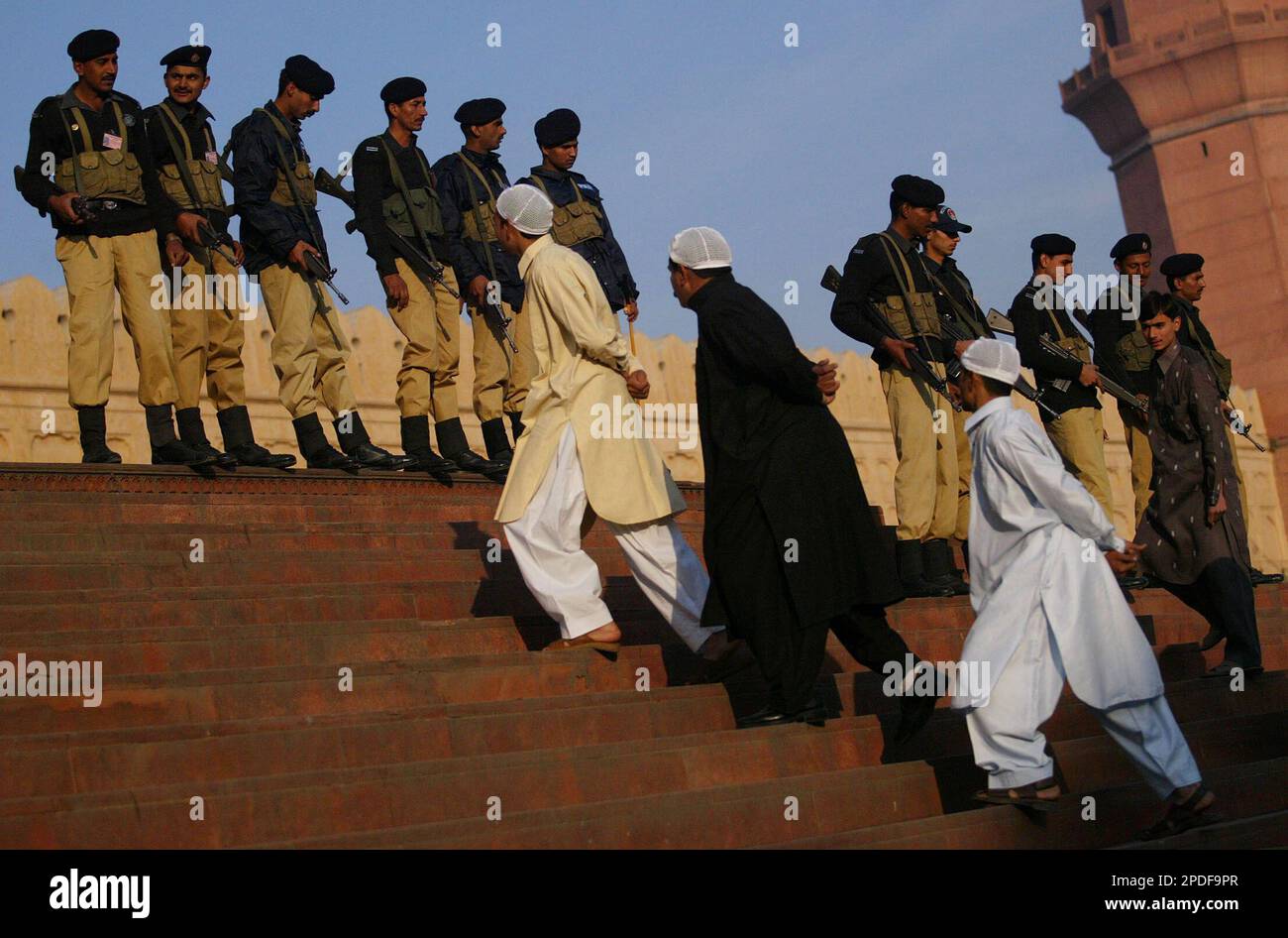 Pakistani policemen stand guard as the devotees enter Badshahi mosque ...