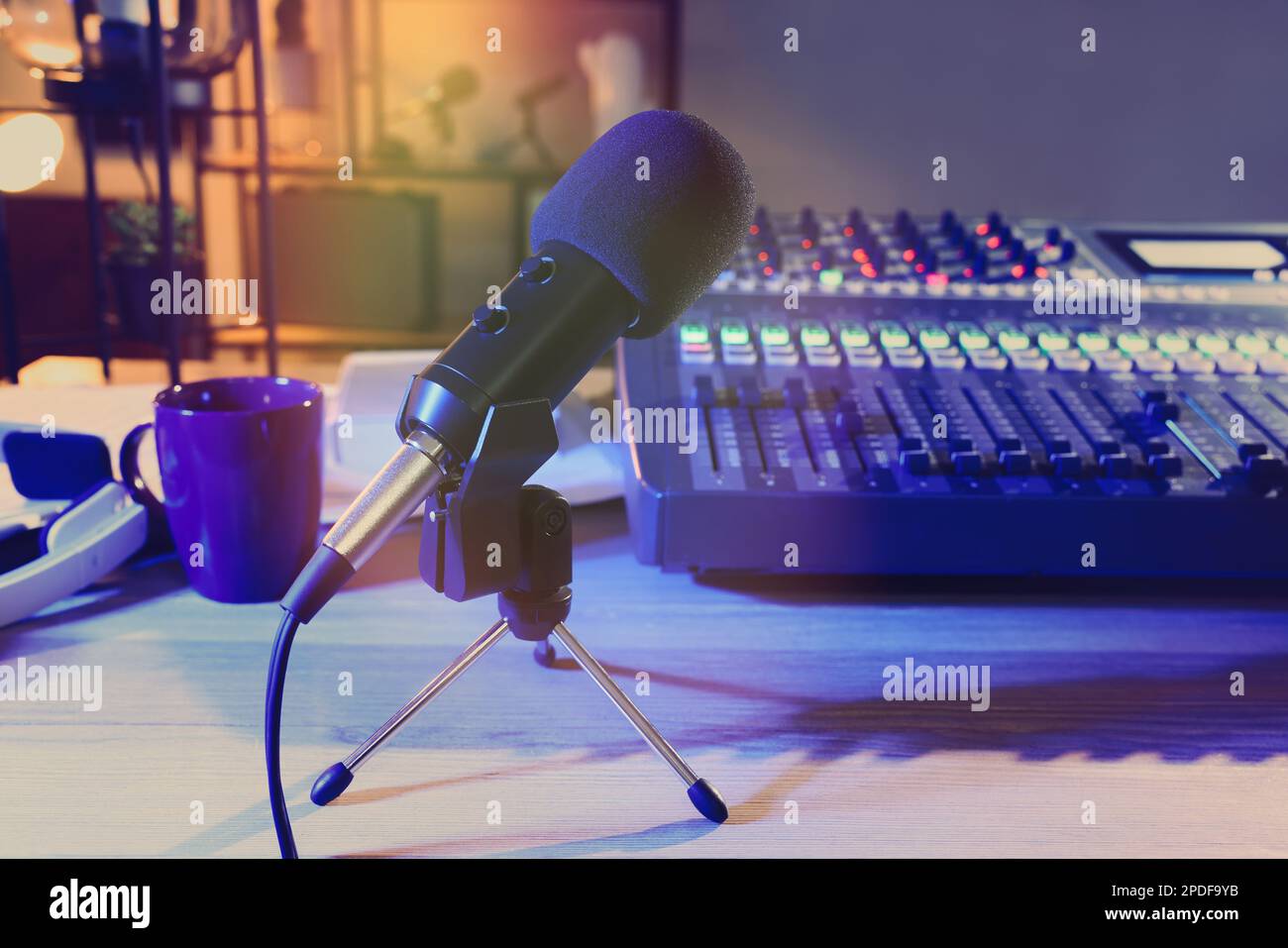 Microphone and professional mixing console on table in radio studio ...