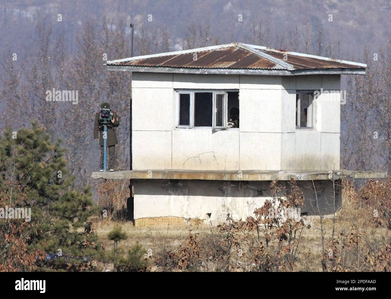 Two North Korean border guards look southwards at the checkpoint ...