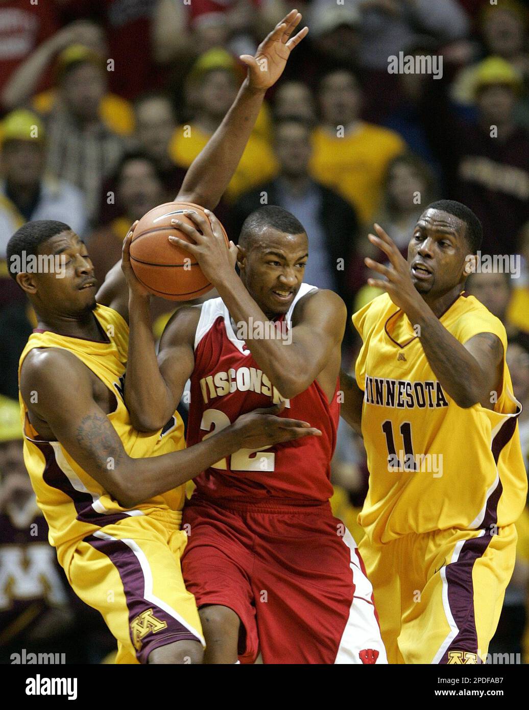 Wisconsin guard Michael Flowers, center, looks to pass under pressure ...