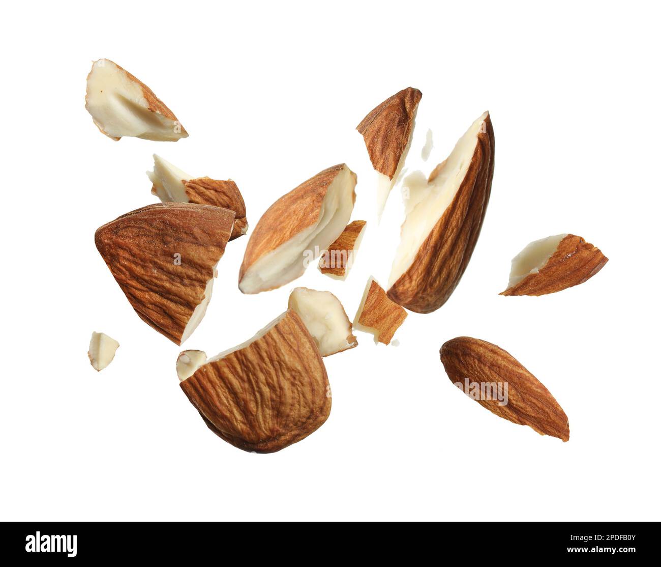Pieces of tasty almonds falling on white background Stock Photo - Alamy