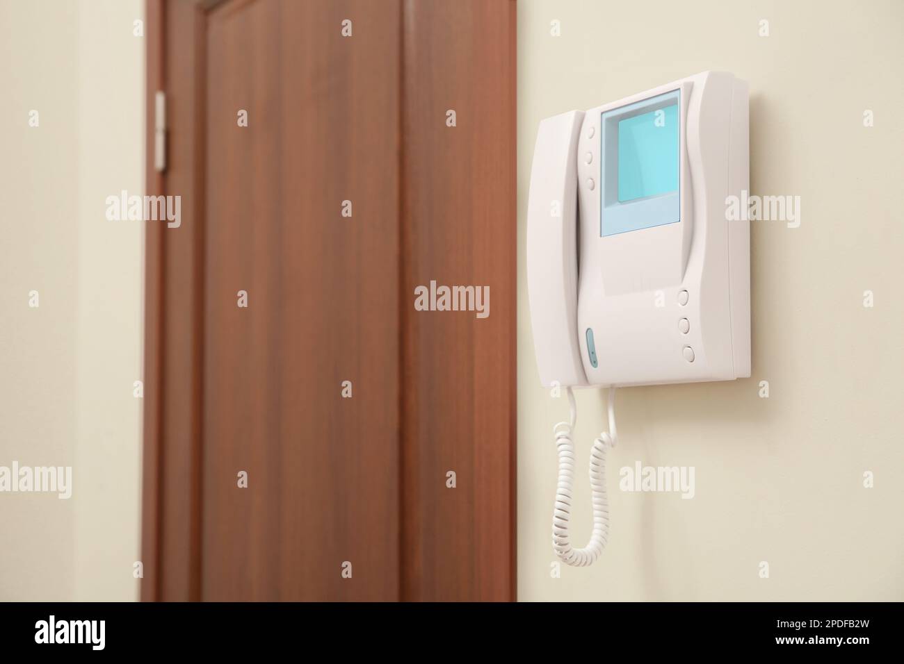 Modern intercom system with handset on white wall indoors, space for ...