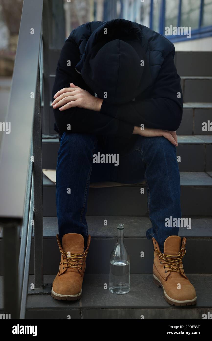 Addicted drunk man with alcoholic drink on stairs outdoors Stock Photo ...
