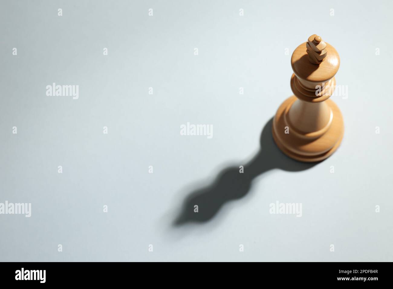 White wooden chess king on light grey background, above view. Space for ...