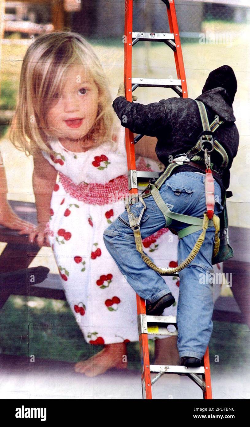 Mike Buttke of Lamar Outdoor Advertising, installs a billboard in ...