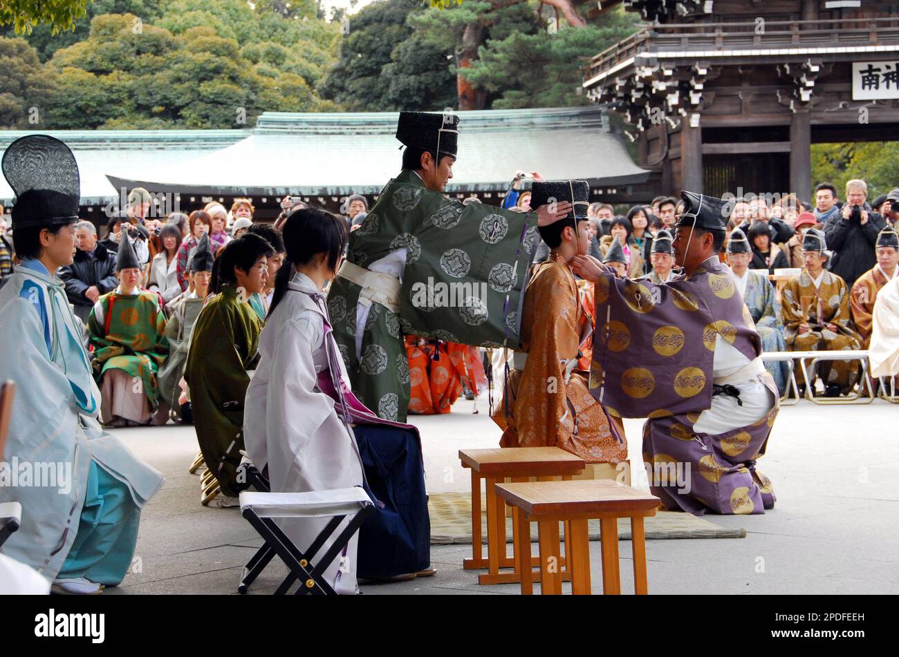 In front of a pack of crowds, Japanese Shinto priests put a traditional ...