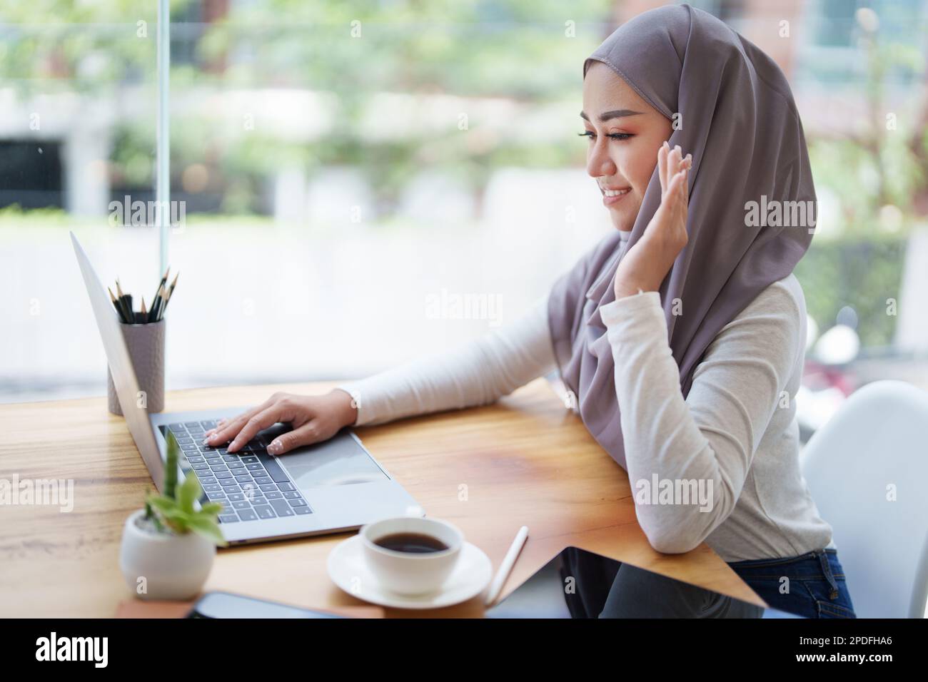 Beautiful Muslim woman using computer to greet attendees via video ...