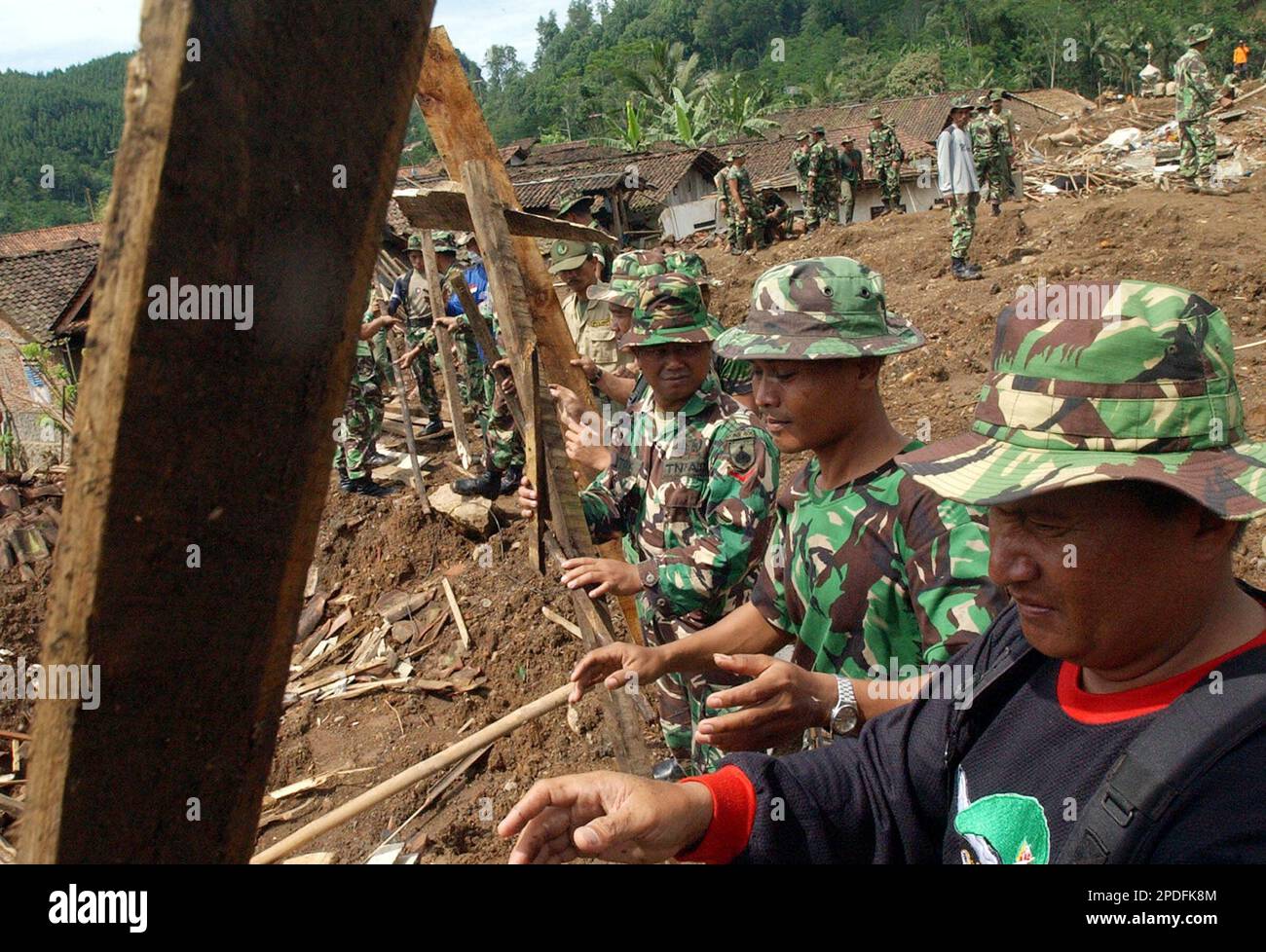 Indonesian soldiers search through debris at Cijeruk village for ...