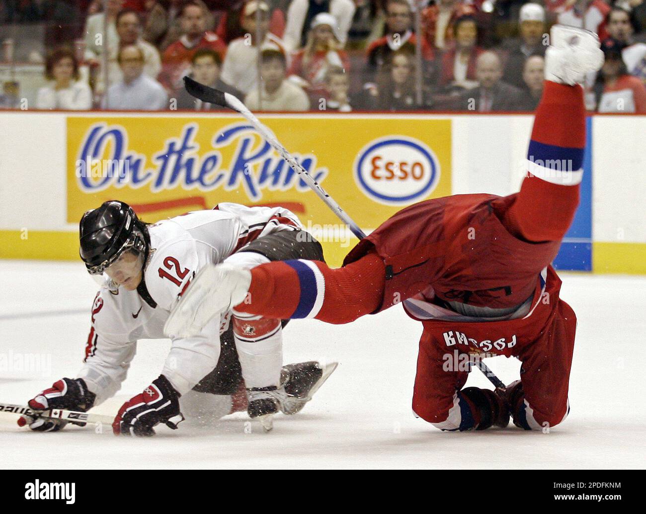 Team Canada's Kristopher Letang sends Team Russia's Nikolai Lemtyugov ...
