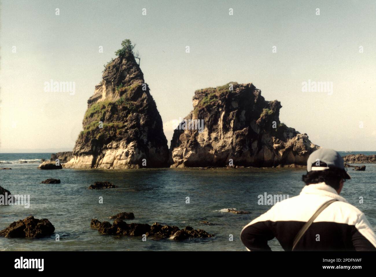 A rock hill popularly called Tanjung Layar (cape sail), in a foreground of a woman visitor and ...