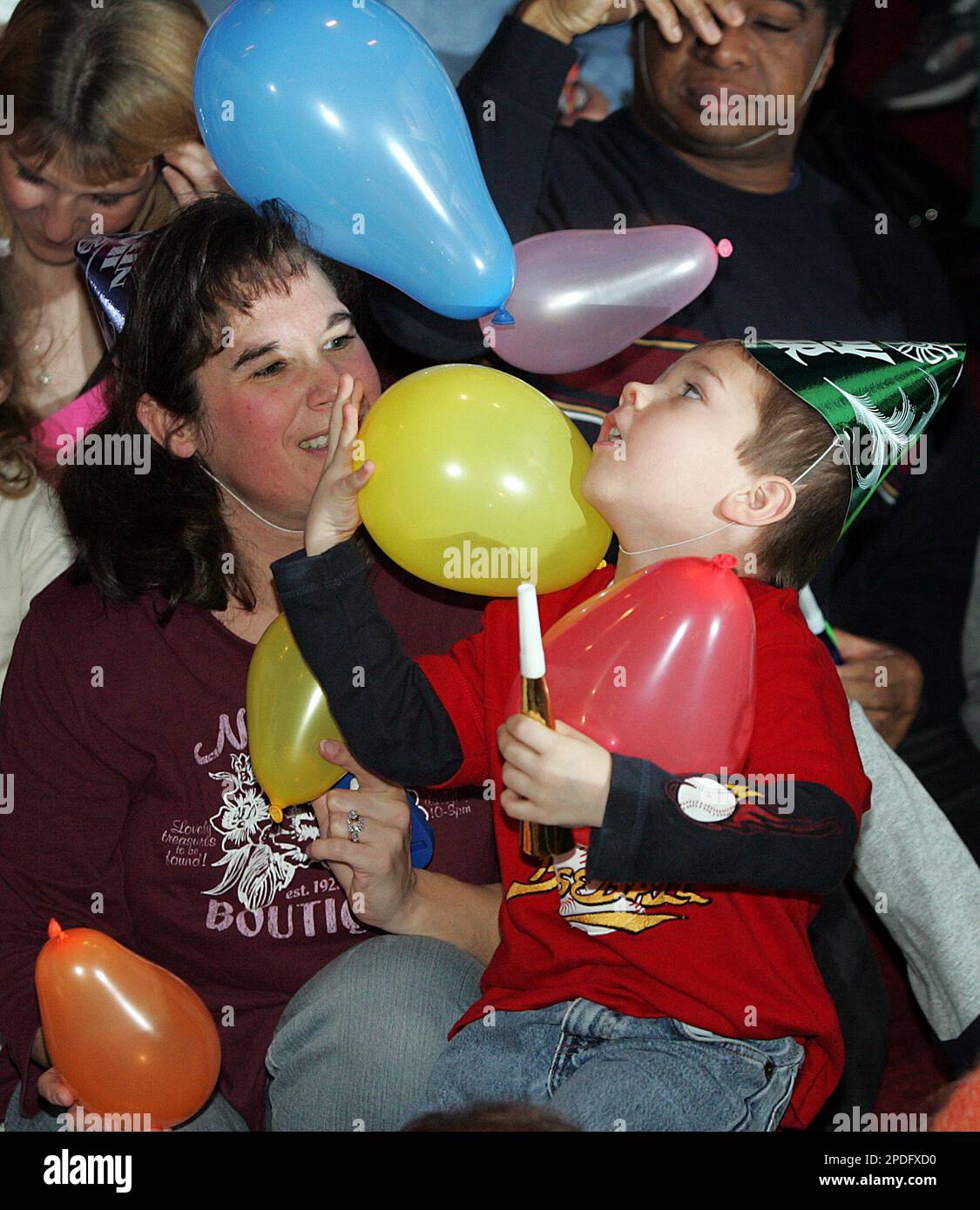 Matthew Lowry, 5, catches falling balloons while sitting on his mother ...