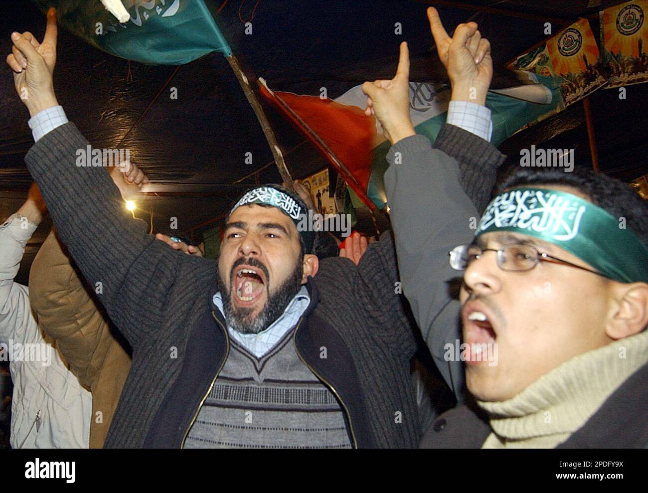 Palestinians holding their national flags and the flags of Hamas ...