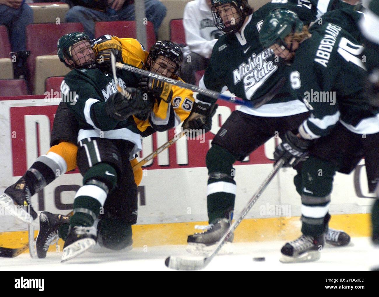 Michigan Technical University's Chris Conner (25), center, gets caught ...
