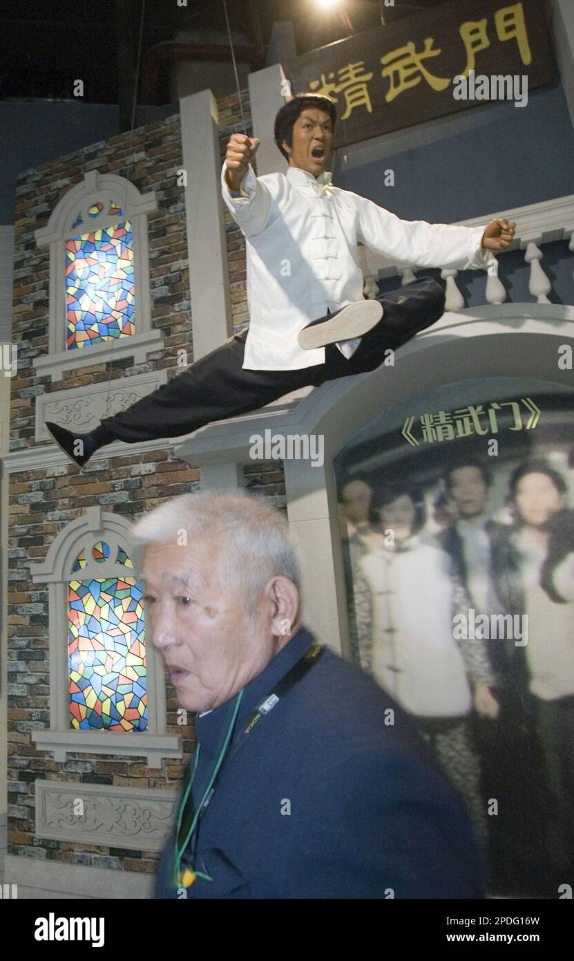 A Chinese visitor walks past a model of famous Chinese movie star Bruce ...