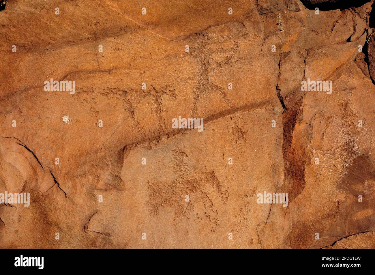 Rock paintings by ancient artists on a flat red stone close-up ...