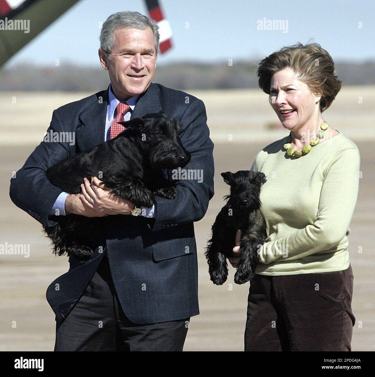 President Bush and first lady, Laura, carry their dogs, Barney and Miss ...