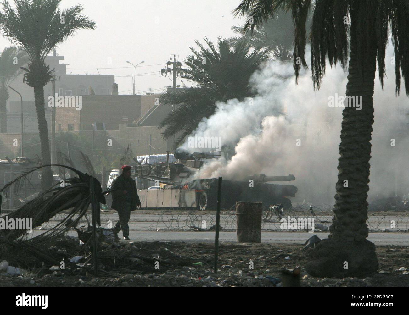 An Iraqi soldier passes a burning U.S. army Abrams tank which caught ...