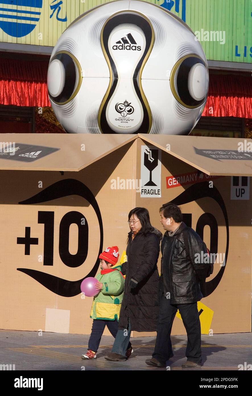 Chinese residents walks past a giant display of the new ball design for ...
