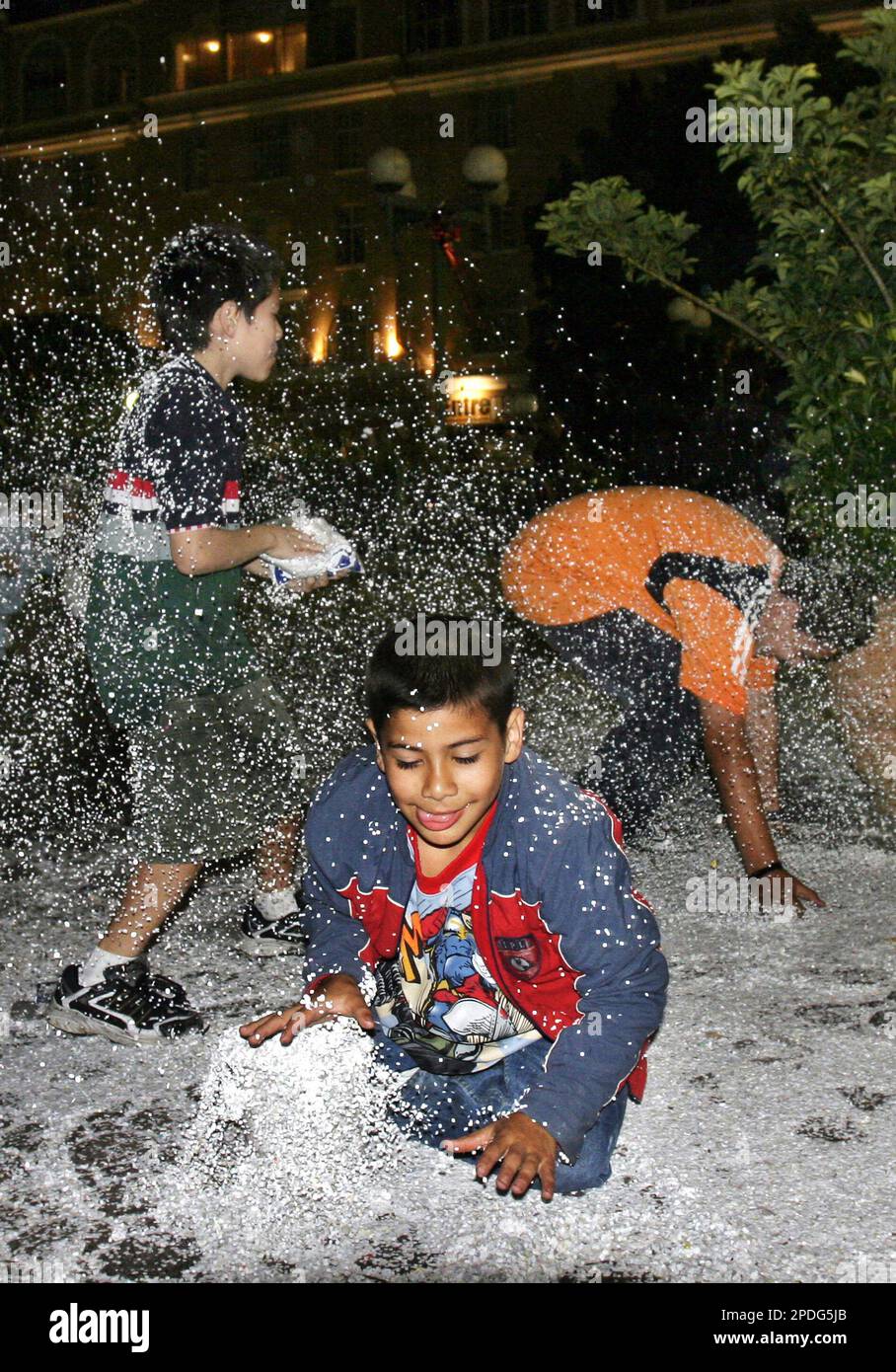 Costa Rican children play in a blizzard of confetti snow during the ...