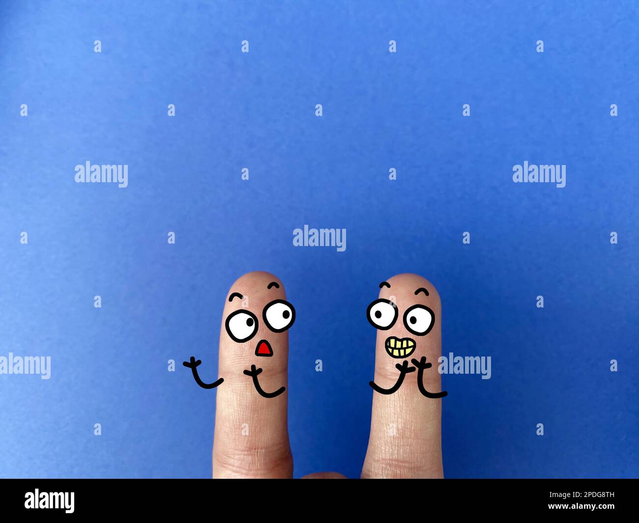 Two fingers are decorated as two person. One of them is having yellow ...