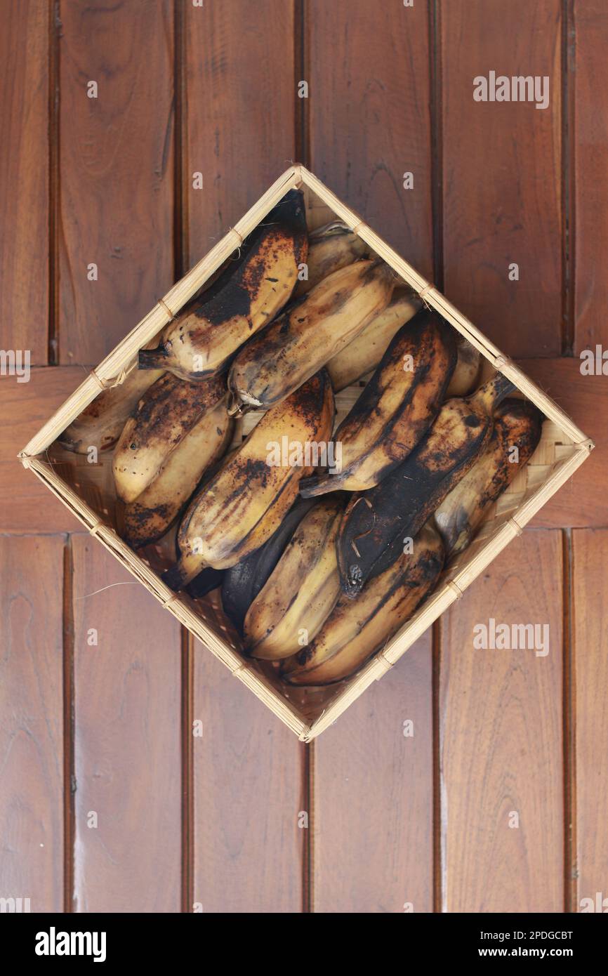 a close up of steamed bananas served on a woven bamboo container Stock ...