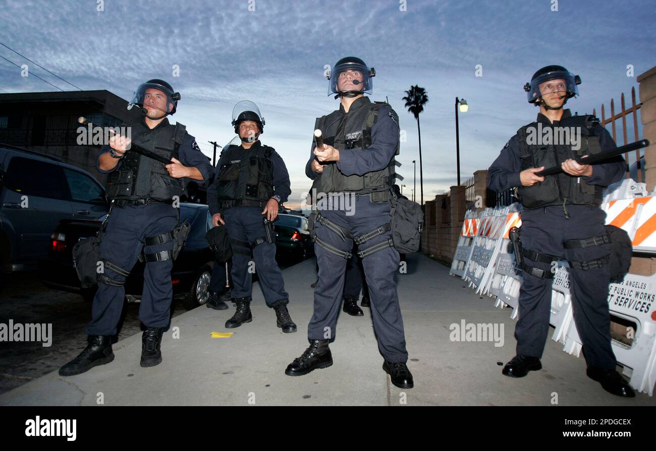 Los Angeles police dressed in riot gear stand watch after the funeral ...