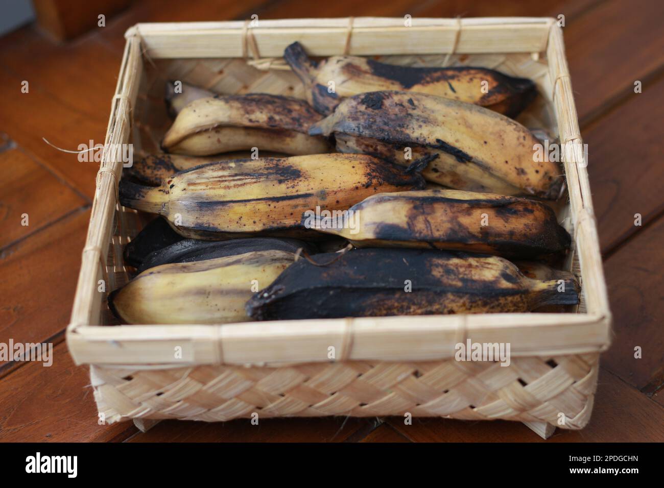 a close up of steamed bananas served on a woven bamboo container Stock ...