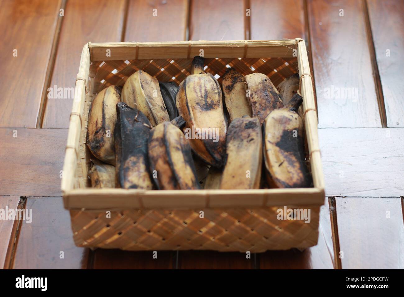 a close up of steamed bananas served on a woven bamboo container Stock ...
