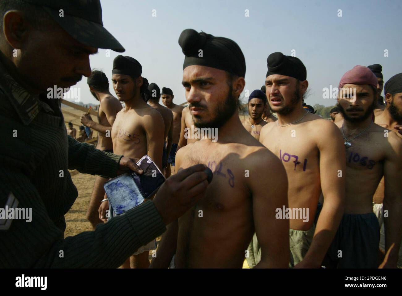 An Indian soldier marks each young hopeful with an identification ...