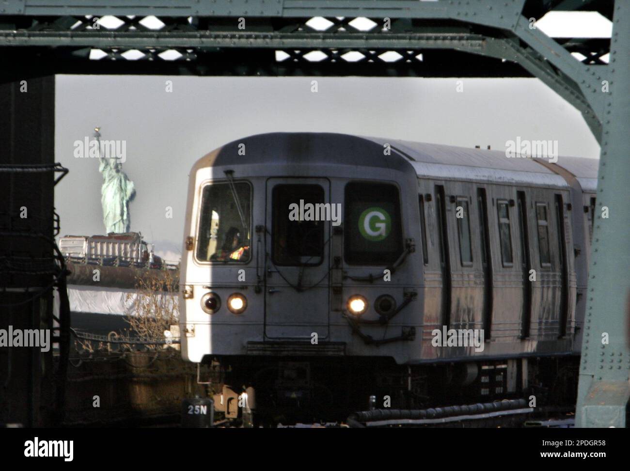 The Statue of Liberty is seen in the background as a subway train ...